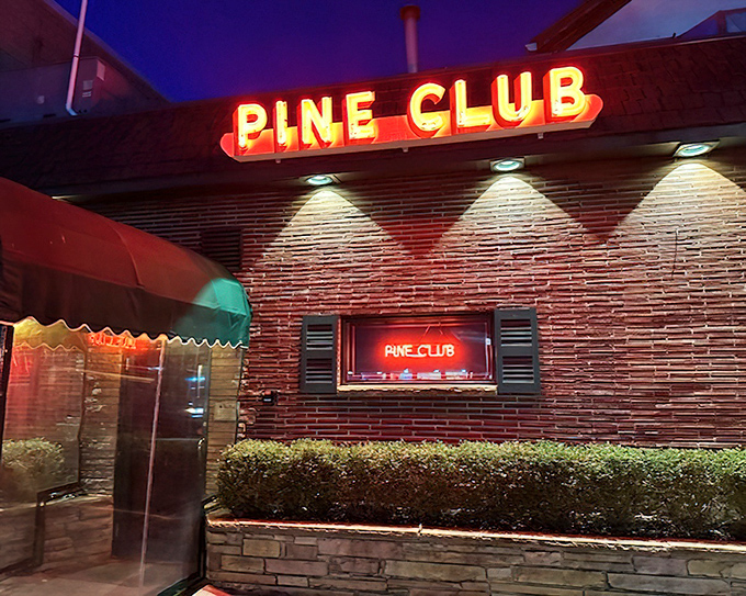 The Pine Club's neon sign glows like a carnivore's North Star. Nighttime transforms this Dayton institution into a beacon of beef brilliance.