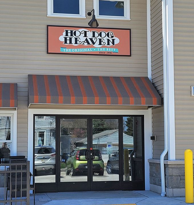 The orange and brown awnings of Hot Dog Heaven offer shade for what locals know is a religious experience in hot dog form.