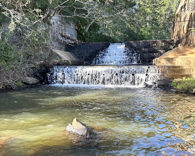 A charming stone dam creates gentle cascades at Indian Springs. The park's historic structures blend harmoniously with natural beauty.