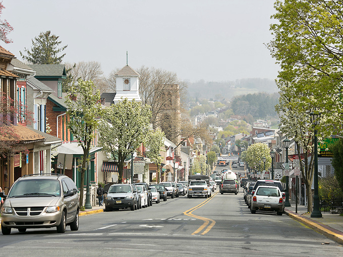 Main Street stretches into the distance like a painting come to life, with colorful buildings standing guard beneath a canopy of spring blossoms.