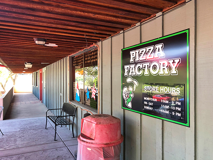 The wooden walkway and covered porch at Pizza Factory offer a moment of rest before diving into pizzas that fuel mountain adventures.