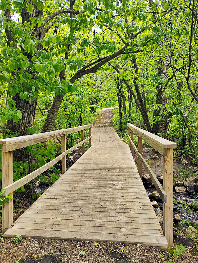 Wooden bridge crossing a peaceful stream, offering the perfect spot for playing "Guess How Long Until Someone Says 'Poohsticks'?"