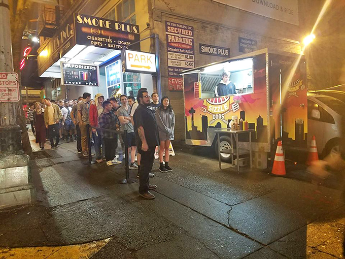 Late night cravings meet their match at Sizzle Dogs, where the line of hungry night owls tells you everything you need to know.