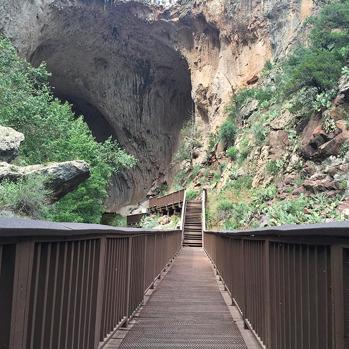 The walkway leading to this geological wonder builds anticipation with every step toward the towering opening.