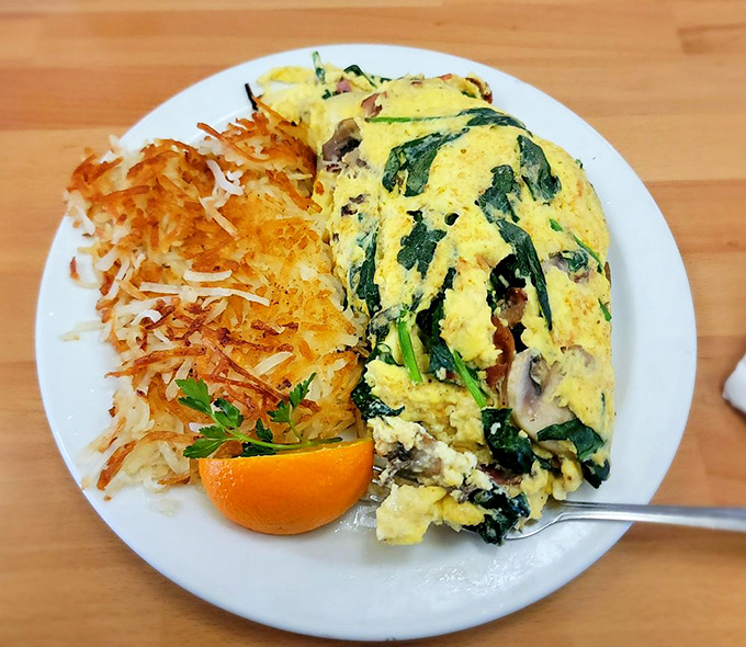 This spinach omelet is what Popeye would order if he had a 401k and weekend plans. The hash browns are the crispy supporting actor.