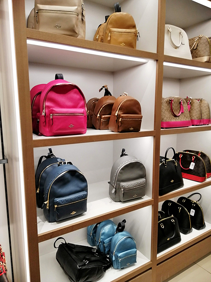 Coach backpacks and handbags await their forever homes. Like a well-organized dating service for accessories and shoppers seeking the perfect match.