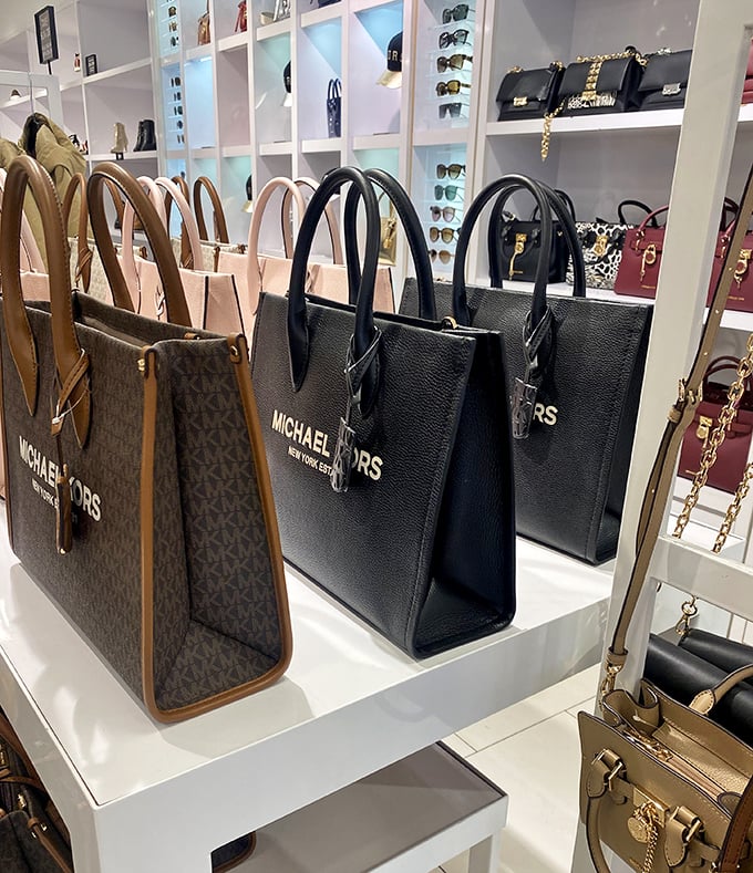 Michael Kors handbags standing at attention. Silent sentinels of style that somehow convince you that black is indeed a different color.