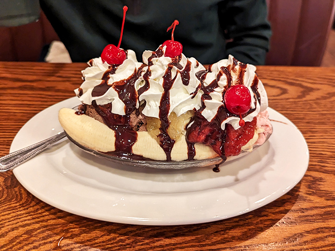 This banana split isn't just dessert—it's an architectural achievement with whipped cream skyscrapers and cherry-topped monuments to sweetness.
