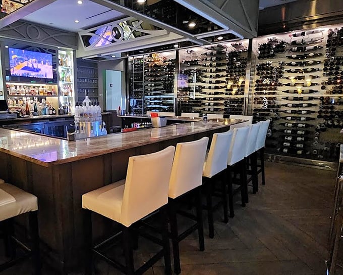 The bar area doubles as a wine lover's dream library, with bottles lining the walls like literary classics waiting to be opened and enjoyed.