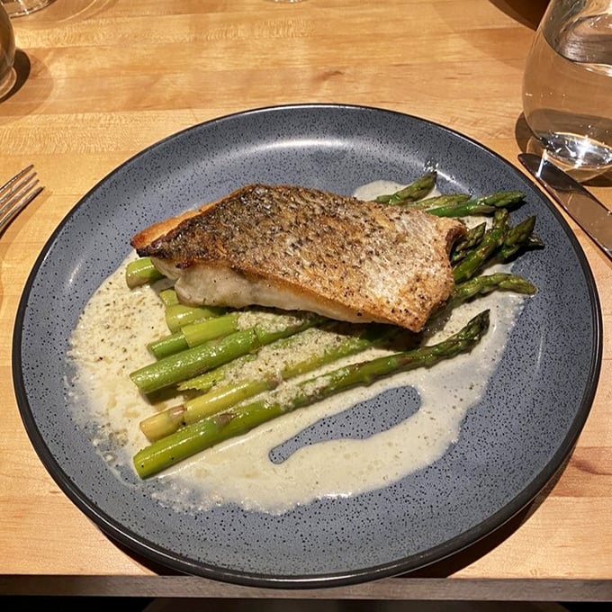 Fish this perfectly seared deserves its own spotlight, with asparagus and sauce creating a stage worthy of the star performer.