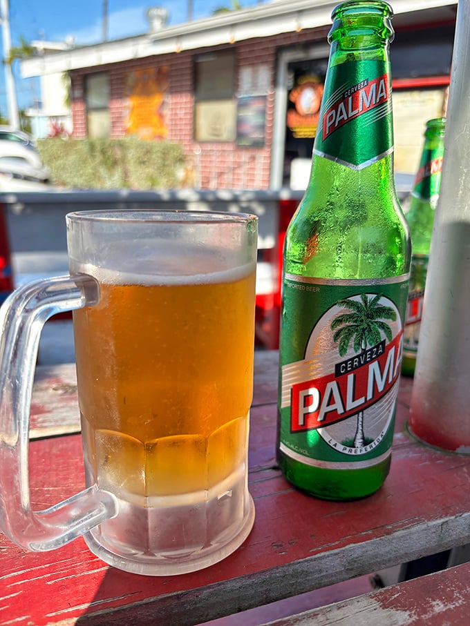 A frosty mug of Palma Cristal beer with the restaurant in the background. In the Florida heat, this might be what salvation tastes like.