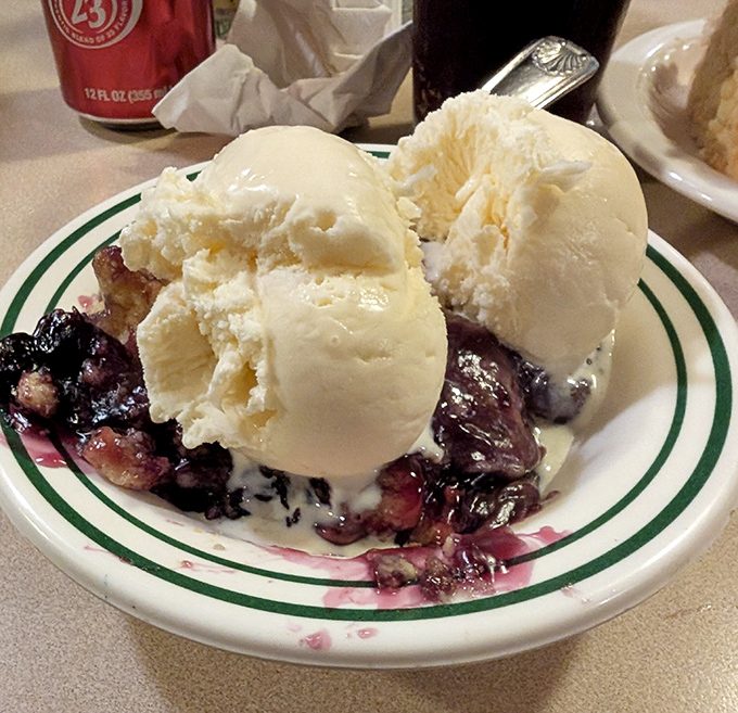 Ice cream melting into warm blueberry cobbler creates that perfect moment when hot meets cold. Dessert physics at its most delicious.