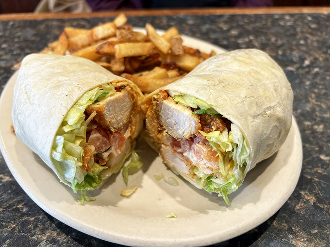 Buffalo chicken wrapped up tight with crispy fries on the side, proving lunch here competes fiercely with breakfast offerings.