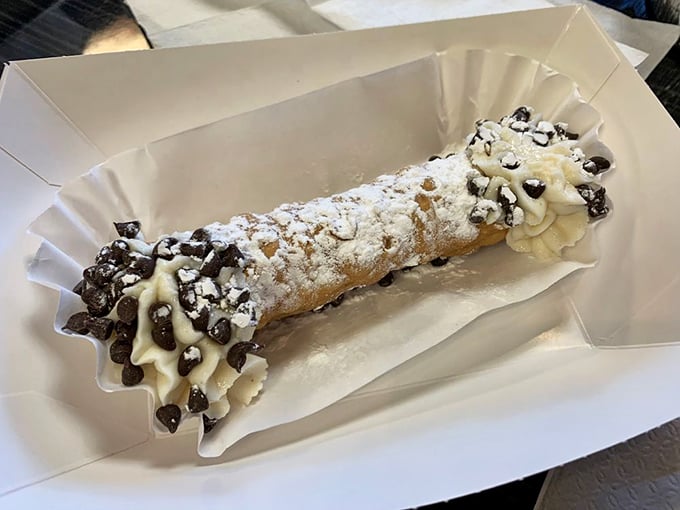 The cannoli: crispy shell, creamy filling, chocolate chips, and enough powdered sugar to make your dentist schedule a vacation.