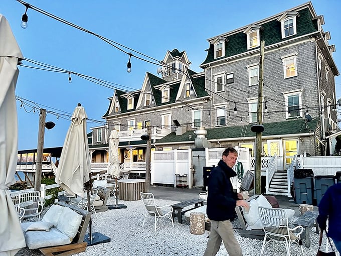 Evening settles over weathered shingles and string lights. This outdoor dining setup captures the essence of summer nights when nobody's in a hurry to leave.