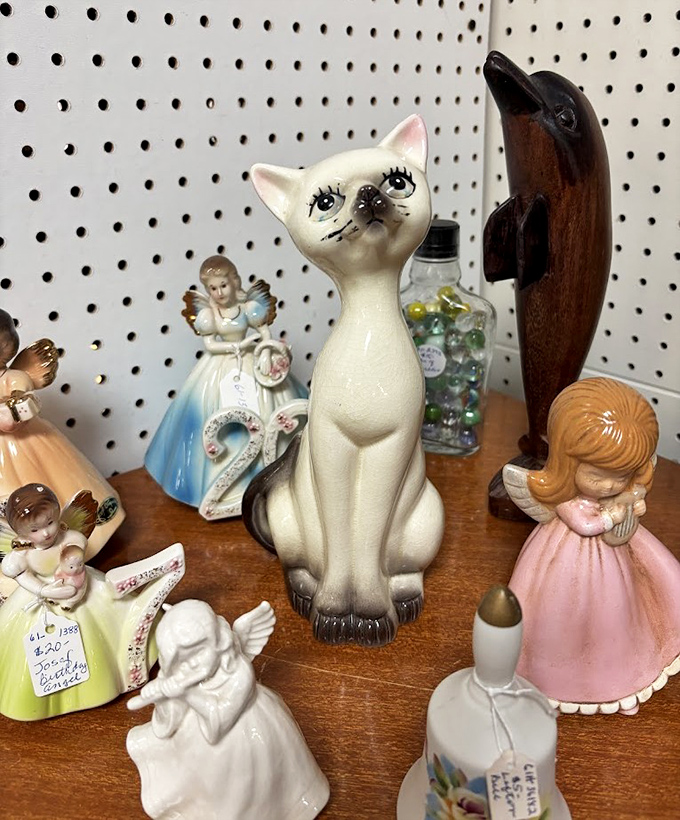 That siamese cat figurine has seen things. The angel collection beside it is probably keeping it in check.