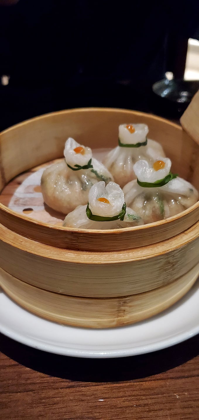 Delicate dumplings tied with green ribbons like little culinary presents, each one hiding treasures of flavor beneath their translucent wrappers.