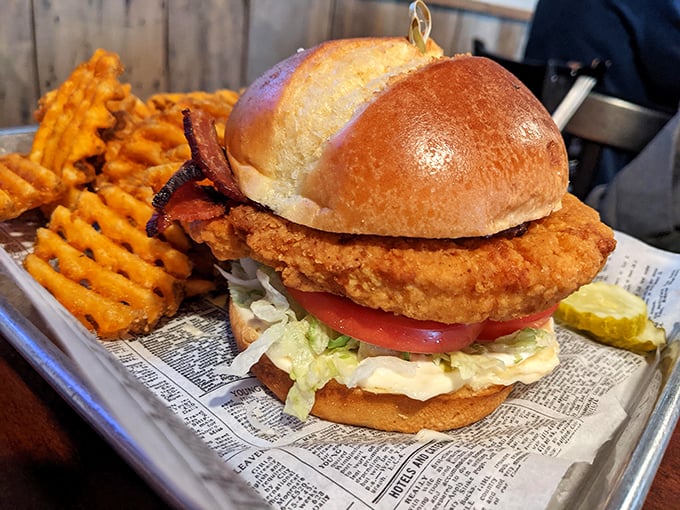 A sandwich that requires both hands and a strategy &ndash; crispy chicken, fresh toppings, and waffle fries that refuse to be ignored.