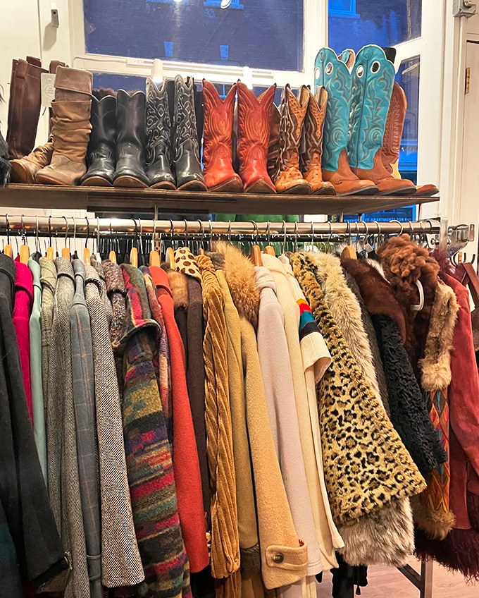 Cowboy boots with stories to tell line the window display, while below, a rainbow of vintage coats stands ready for their second act.