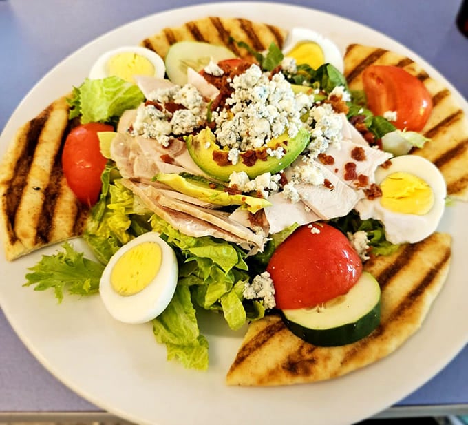 This Cobb salad isn't just a salad – it's a colorful landscape of flavors surrounded by grilled pita. Garden of Eden on a plate.