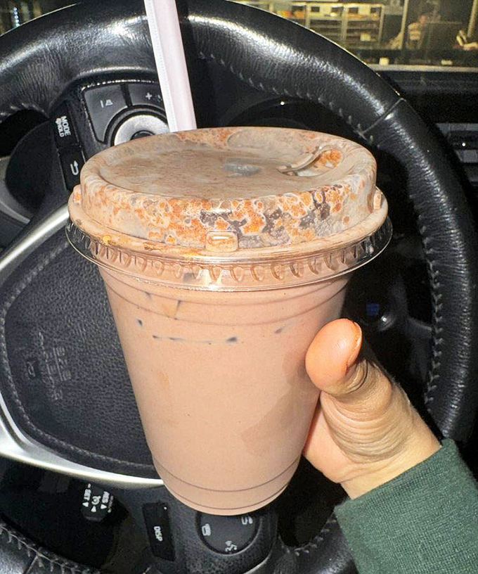 That chocolate drink sitting in the cupholder suggests someone's morning commute just got exponentially better than yours.