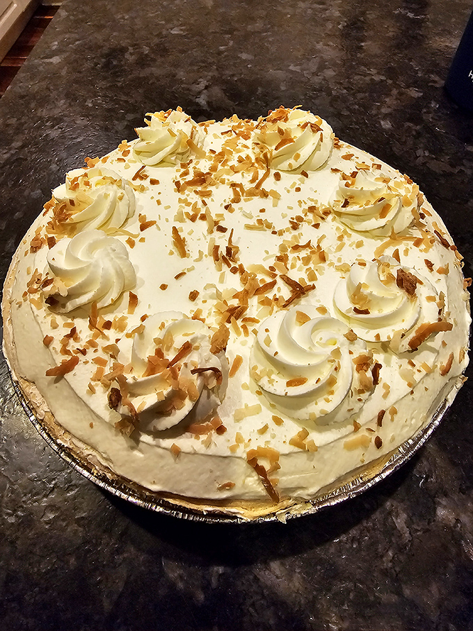 Whipped cream rosettes dance across this coconut-topped masterpiece&mdash;a cake that whispers "special occasion" even on an ordinary Tuesday.