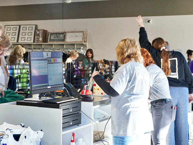 Checkout time! Friendly staff process treasures with efficiency while shoppers eagerly await that final total&mdash;usually a fraction of what they expected.
