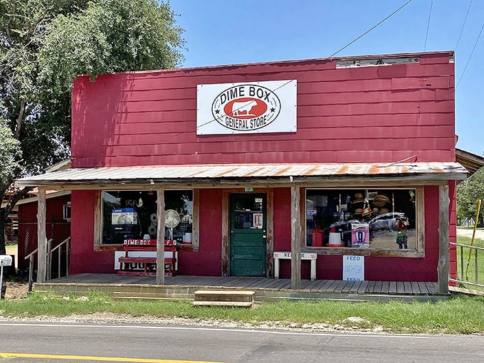The heart of Dime Box commerce. The General Store's weathered red facade has likely witnessed decades of visitors coming to see the town's famous coin.