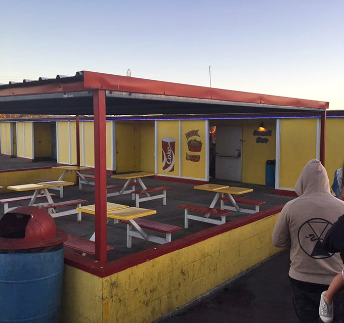 Red and yellow picnic tables await intermission crowds, offering a chance to stretch legs and debate plot twists under the stars.