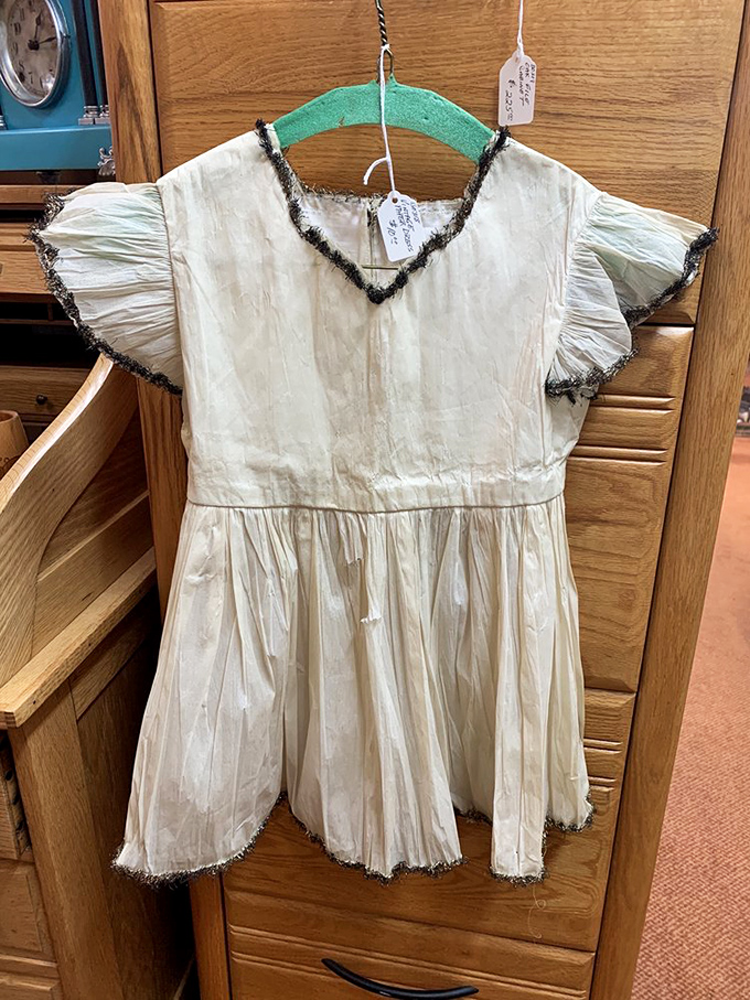 This delicate child's dress whispers of Sunday services and special occasions from an era when clothes were treasured, not disposable.