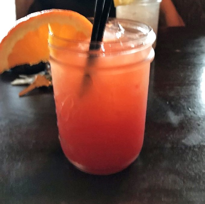 This sunset-colored cocktail isn't just a drink, it's a vacation in a glass, complete with the orange slice that says "relax, you've earned this."