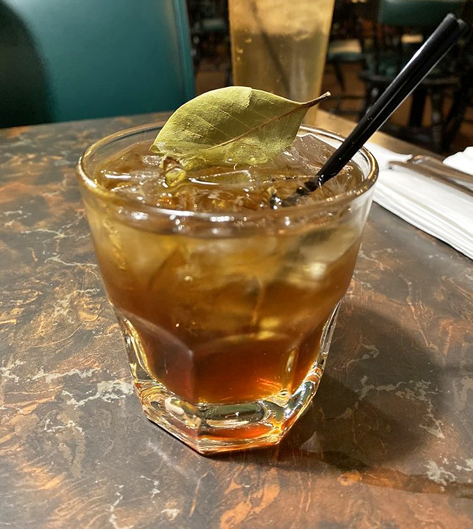 Not just a drink, but a conversation piece. This cocktail, garnished with a bay leaf, offers a moment of refined pleasure amid slider madness.