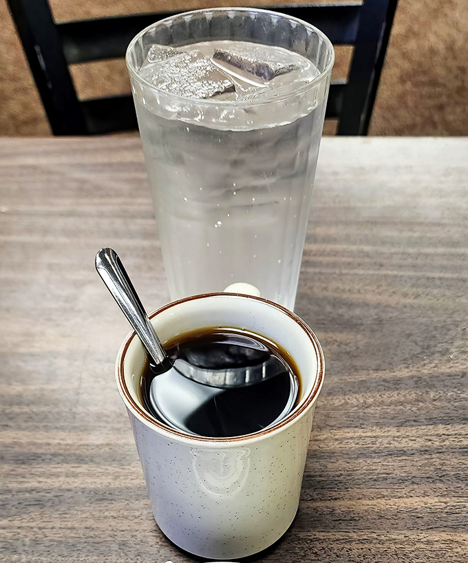 The classic diner duo: no-nonsense coffee in a sturdy mug and ice water in a tall glass. Simple pleasures that never disappoint.