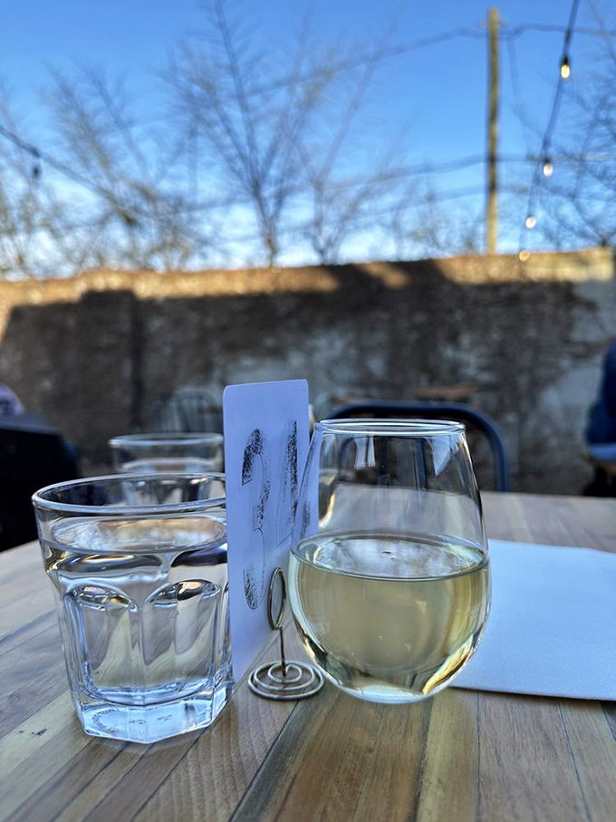As dusk settles over Atlanta, a glass of crisp white wine becomes the perfect companion to Staplehouse's outdoor dining experience.