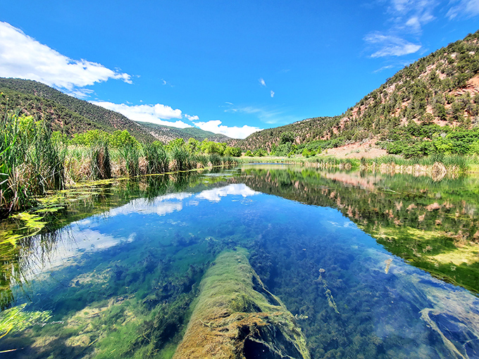 East Rifle Creek's crystal-clear waters reflect the surrounding mountains with such precision, it's like nature's own high-definition mirror.