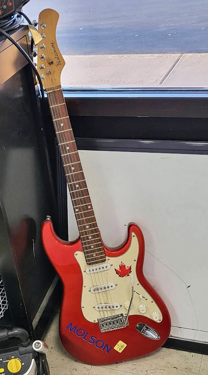 That red Stratocaster-style electric guitar whispers rock star dreams at thrift store prices &ndash; Clapton would understand.