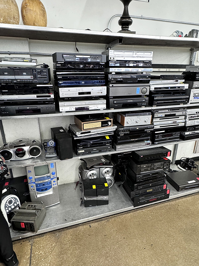A technological time capsule where DVD players, stereos, and VCRs from bygone eras await nostalgic adopters or creative repurposers.