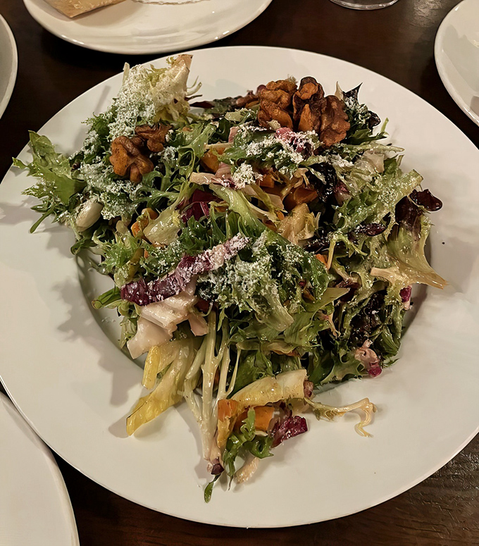 Fresh greens topped with candied walnuts proving that even salads can be exciting when someone actually cares about what they're doing. 