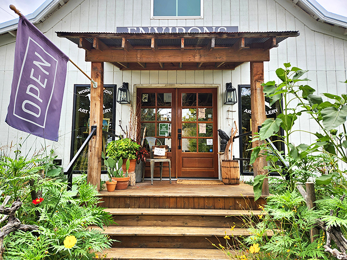 Environsart's inviting wooden porch and lush garden create the kind of entrance that makes you want to linger, browse, and possibly move in.