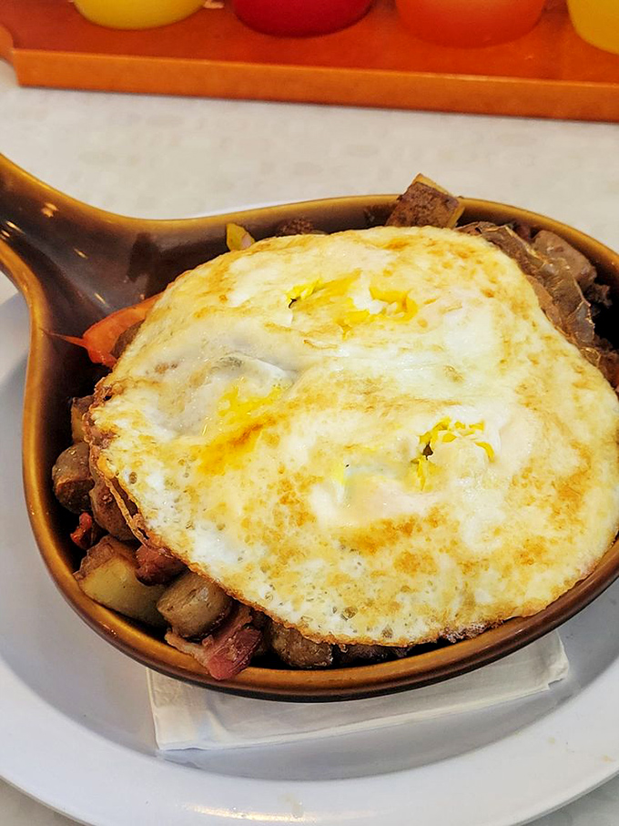 Beneath that perfectly cooked egg lies a treasure trove of breakfast potatoes and savory delights &ndash; archaeology never tasted so good.