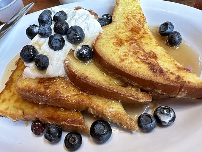 French toast that's achieved the impossible trifecta: golden-crisp exterior, custardy center, and fresh blueberries that pop with each heavenly bite.