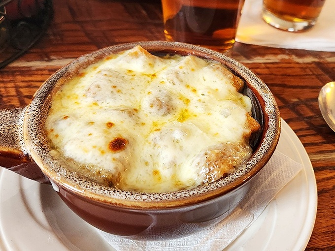 French onion soup done right&mdash;a bubbling cauldron of sweet onions and savory broth under a blanket of cheese that stretches from spoon to mouth like a dairy tightrope.