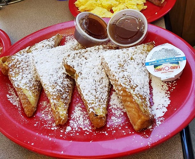 French toast dusted with powdered sugar &ndash; each triangle a gateway to childhood memories, elevated by maple syrup's sweet embrace.