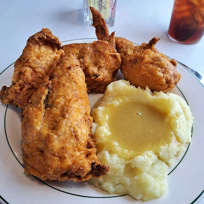 Fried chicken with a crust so perfect it deserves its own Instagram account, alongside mashed potatoes with a gravy divot that's engineering genius.