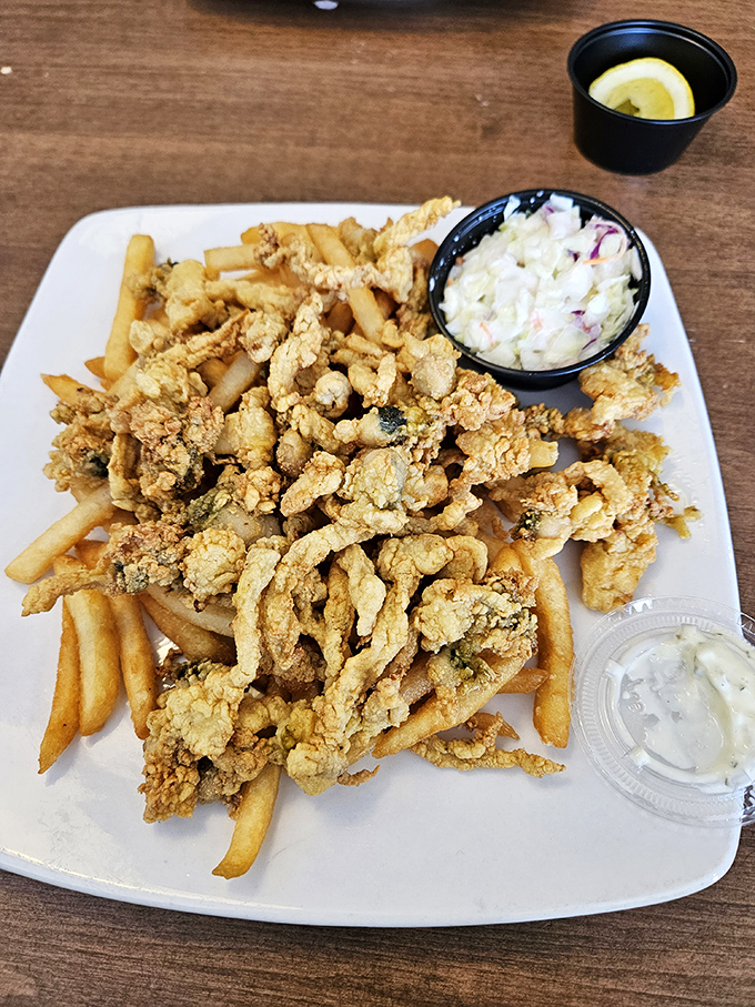 The holy grail of New England seafood&mdash;golden fried clams nestled among crispy fries with coleslaw playing the perfect supporting role. A symphony of crunch and tender sweetness.