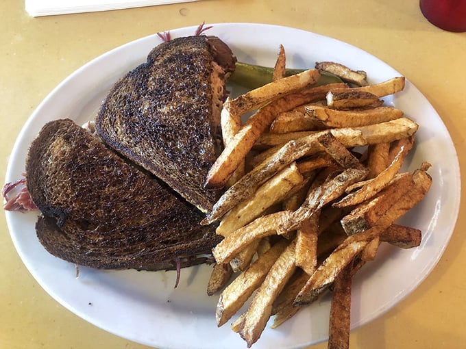 The Reuben sandwich and fries &ndash; a study in contrasts where toasty meets melty, crispy meets tender.