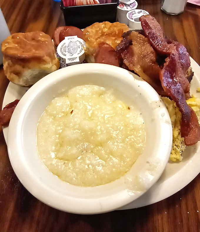 Grits so creamy and comforting they could solve international conflicts, served alongside bacon that clearly lived its best life.