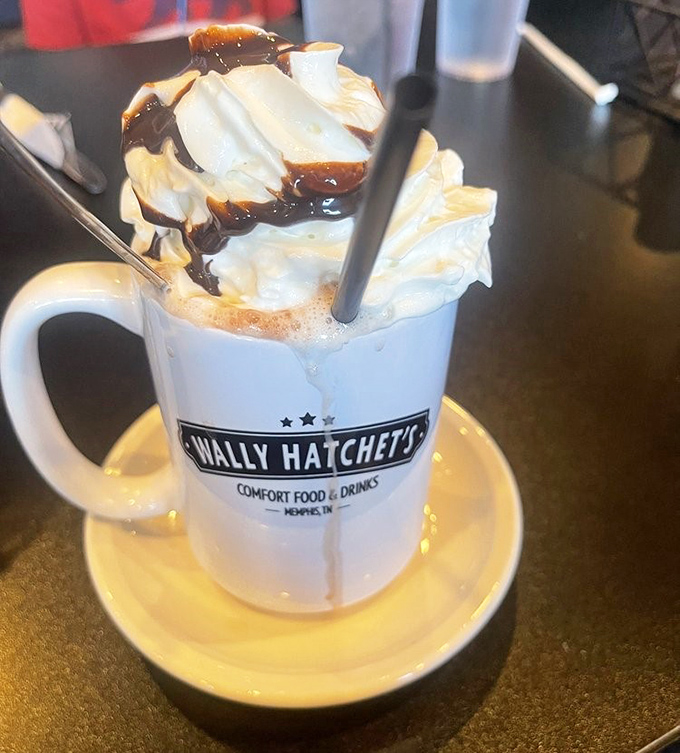 Decadent hot chocolate topped with whipped cream and chocolate drizzle in a branded mug, pure liquid comfort food.