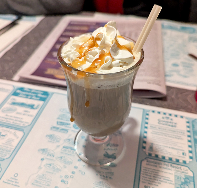 Not just hot chocolate, but a dessert masquerading as a beverage, crowned with whipped cream and caramel that demands to be photographed.