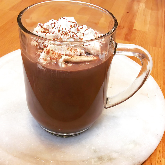 Hot chocolate that demands to be sipped slowly. That cloud of whipped cream with cinnamon dust is basically a pillow for your taste buds.